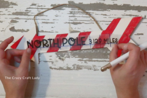DIY Candy Cane Stripe North Pole Arrow Sign - The Crazy Craft Lady